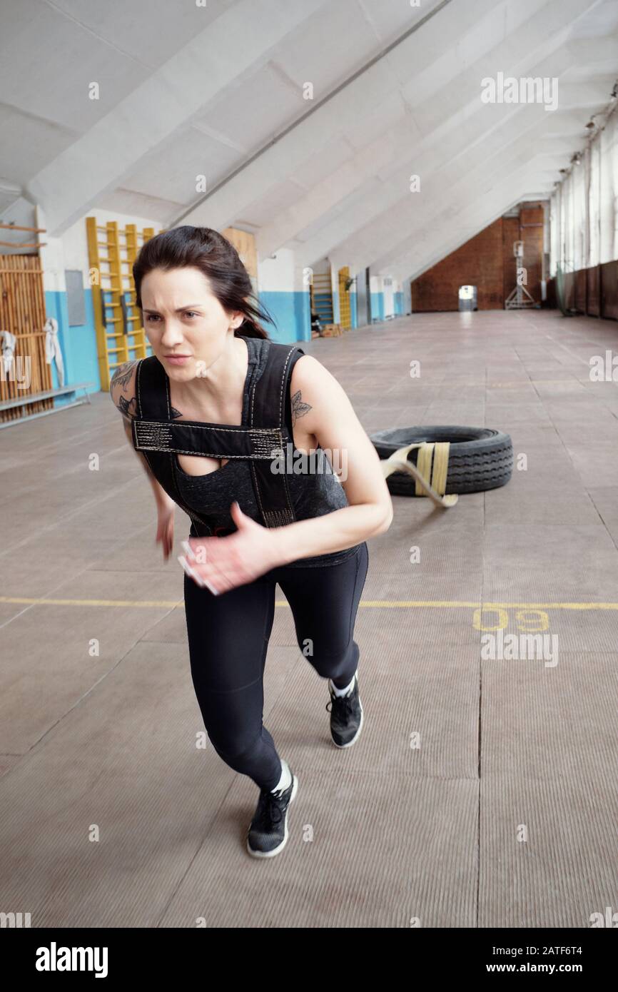 Young attractive Caucasian sportswoman dragging tire Stock Photo - Alamy
