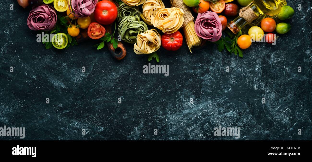 Pasta background. dry pasta tagliatelle and ingredients on black ...