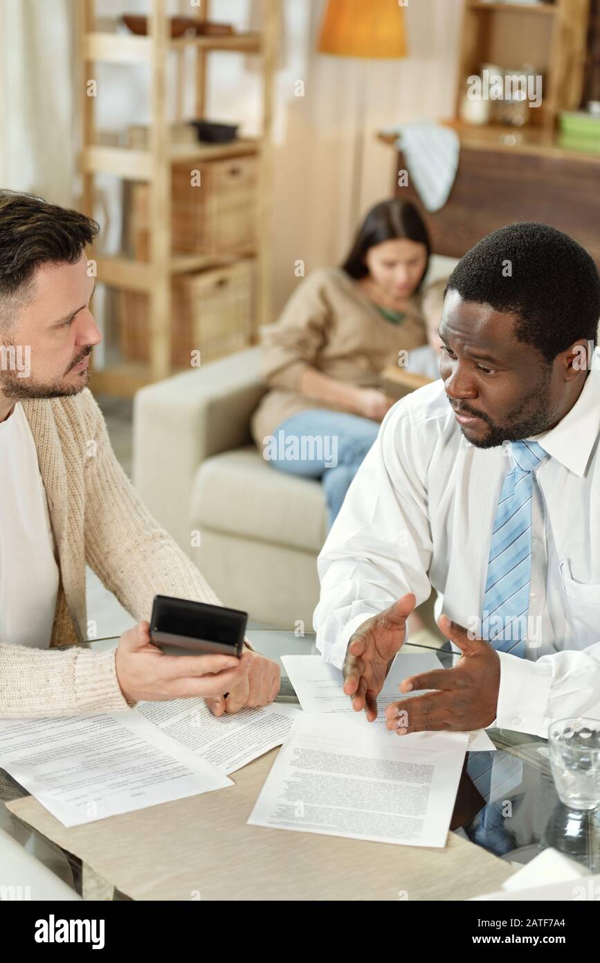 Black man helping client with loan calculation Stock Photo - Alamy