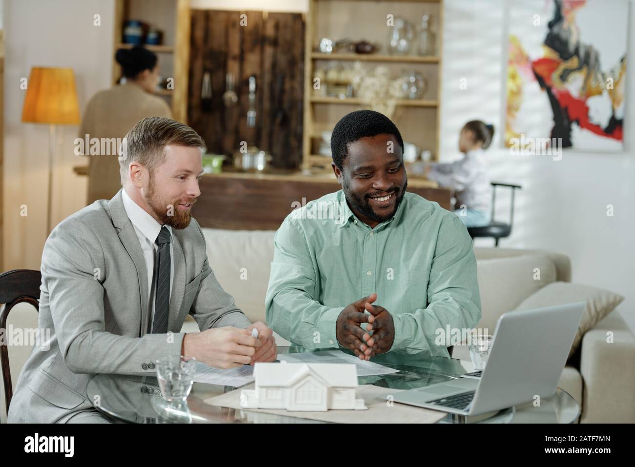 Adviser with cheerful man watching computer Stock Photo - Alamy