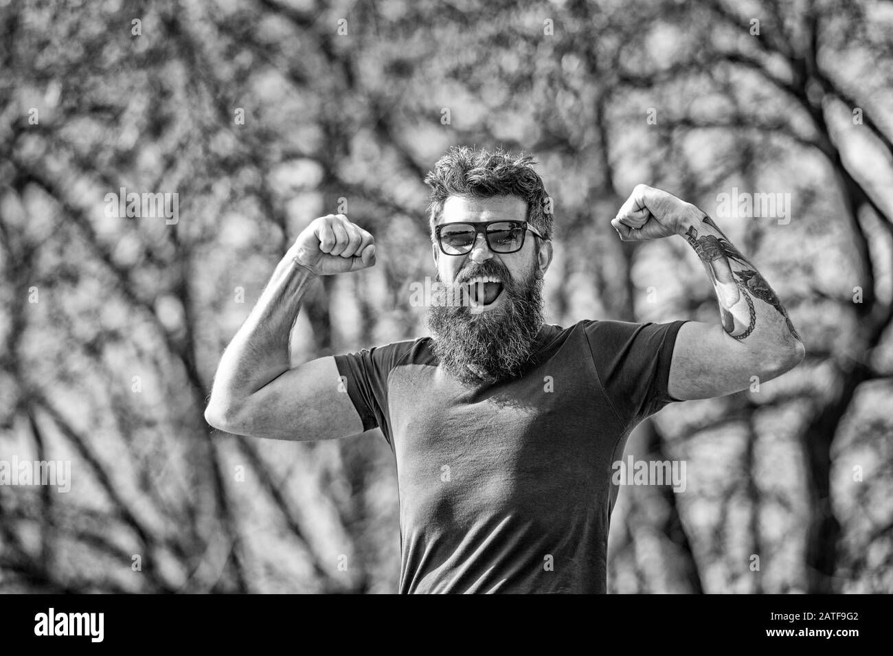 Bearded man shows muscles, biceps on sunny day. Masculinity concept ...