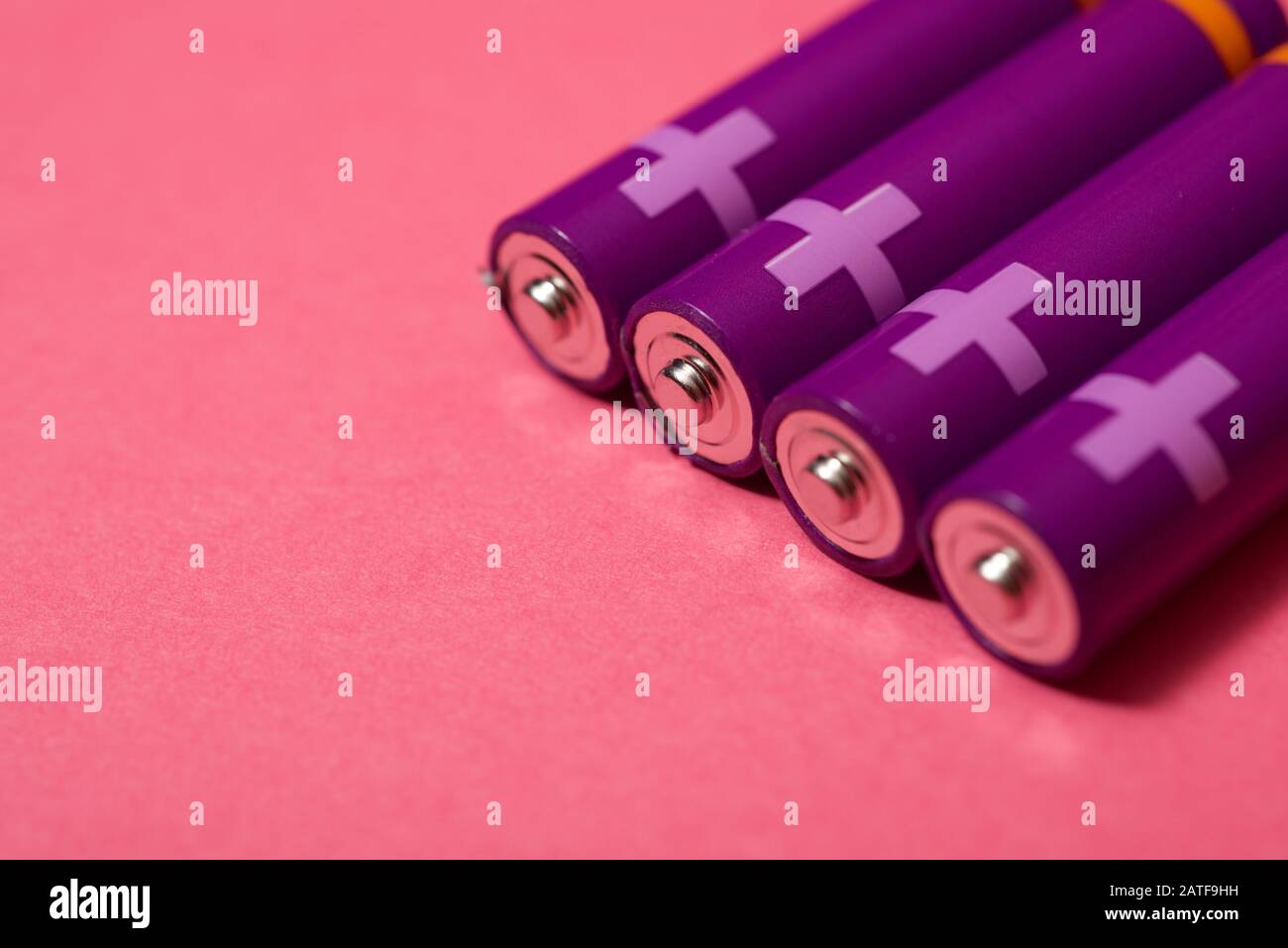 Four small batteries on a pink table Stock Photo - Alamy