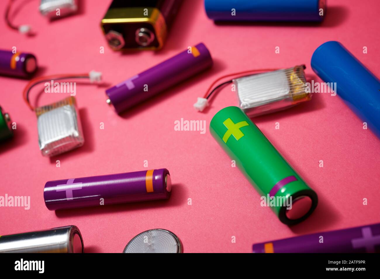Many batteries on a pink table Stock Photo - Alamy