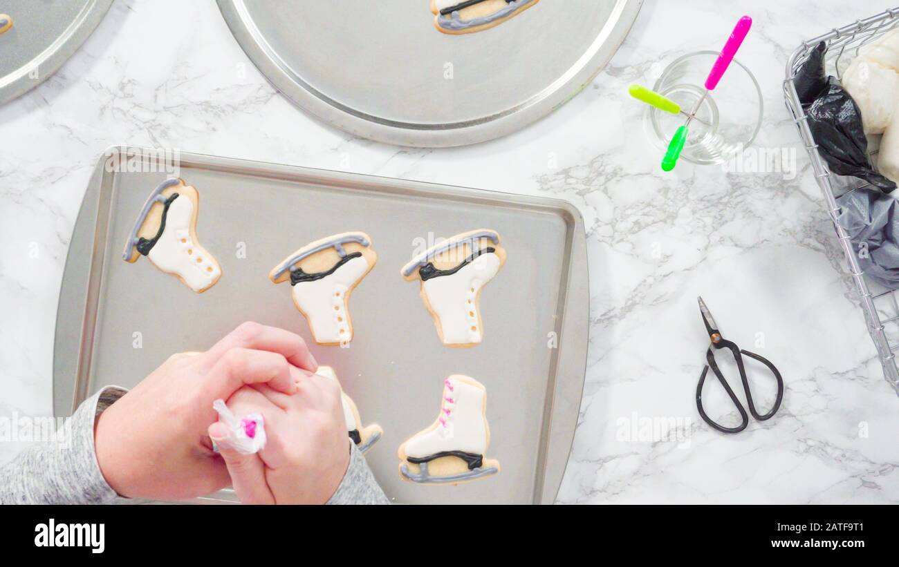 Flat lay. Icing figure skate shaped sugar cookies with royal icing ...