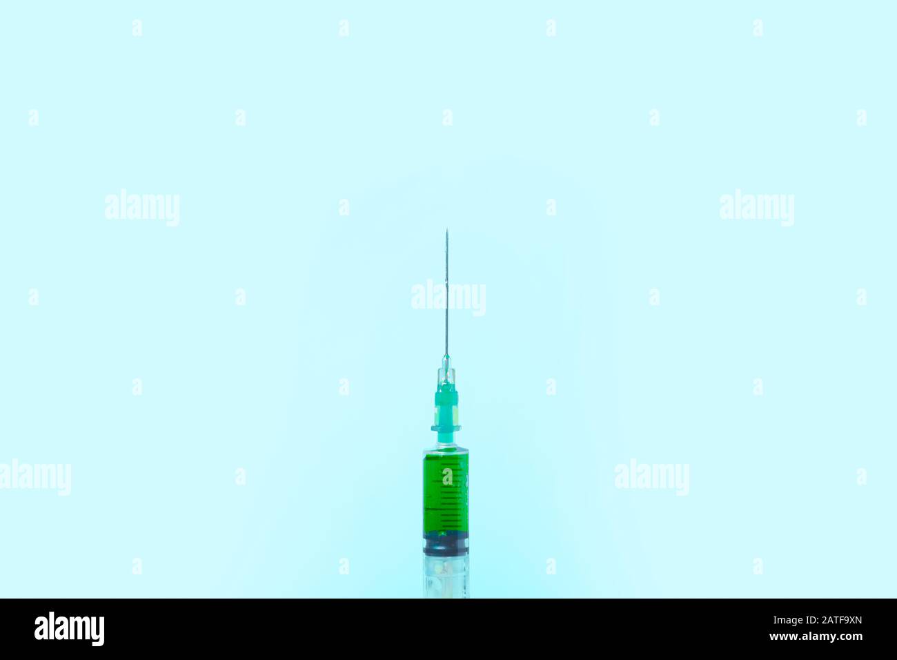 green liquid in a syringe on a blue background, concept of antiviral ...