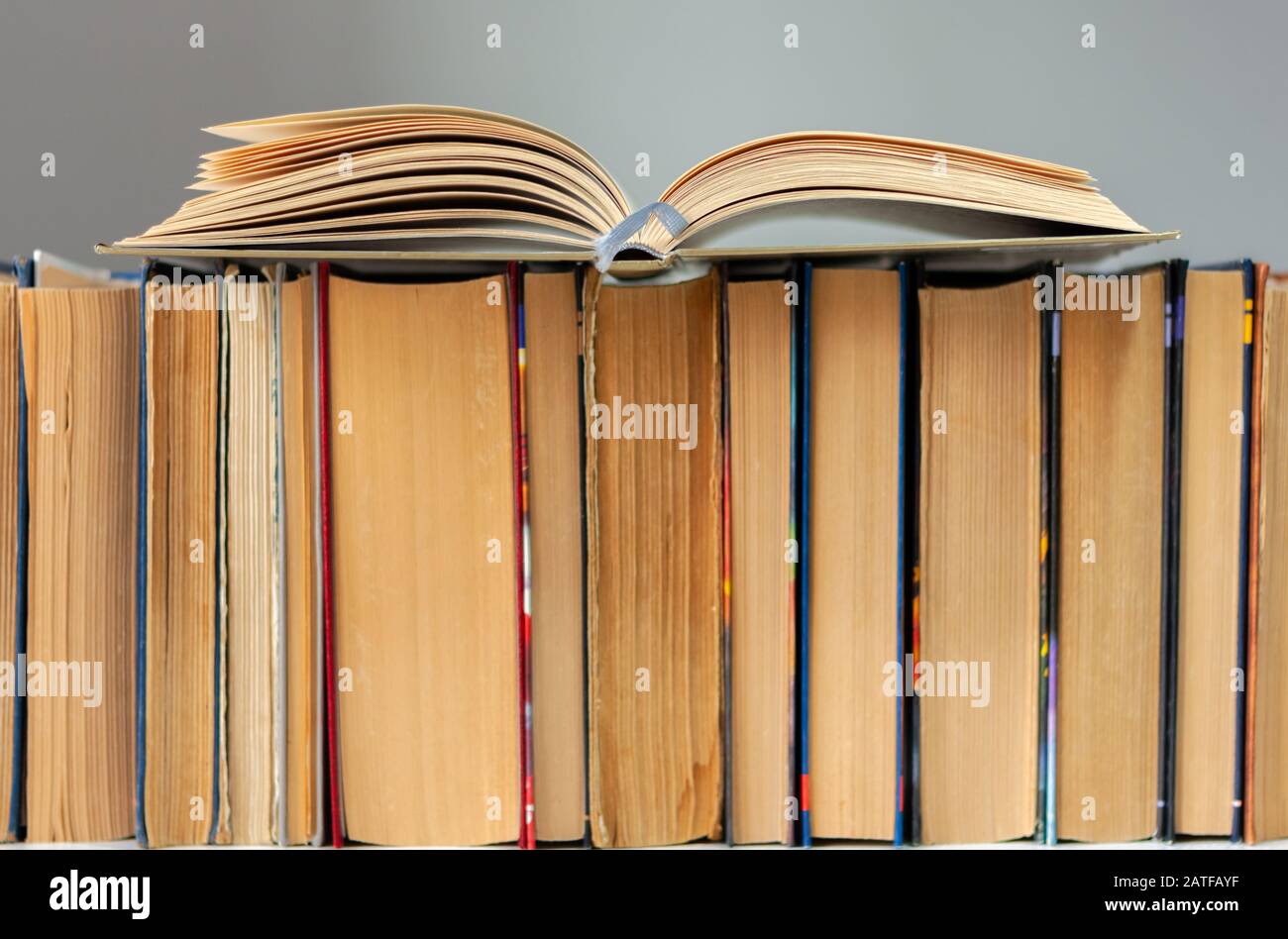 Open hardback book, diary, fanned pages on stack of books on white ...