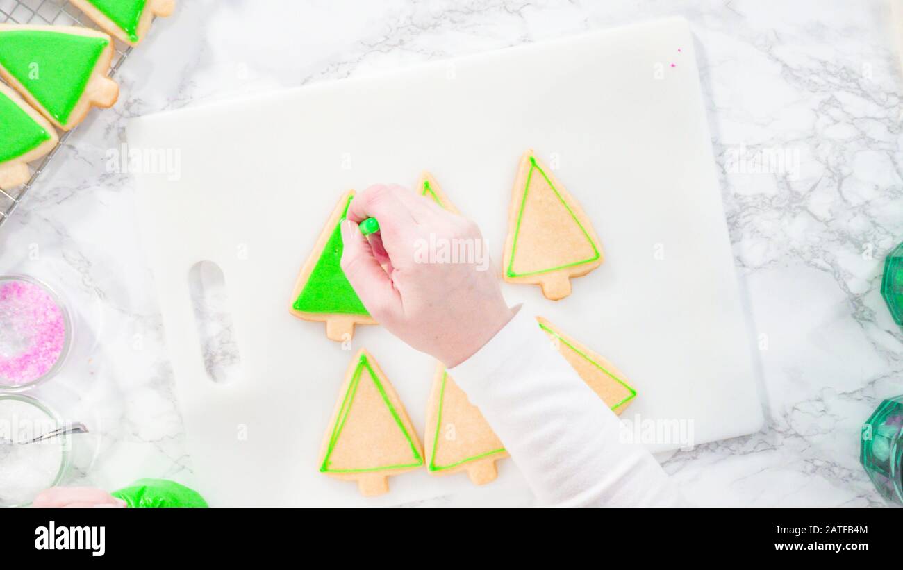 Flat lay. Stp by step. Icing Christmas tree-shaped sugar cookies with ...