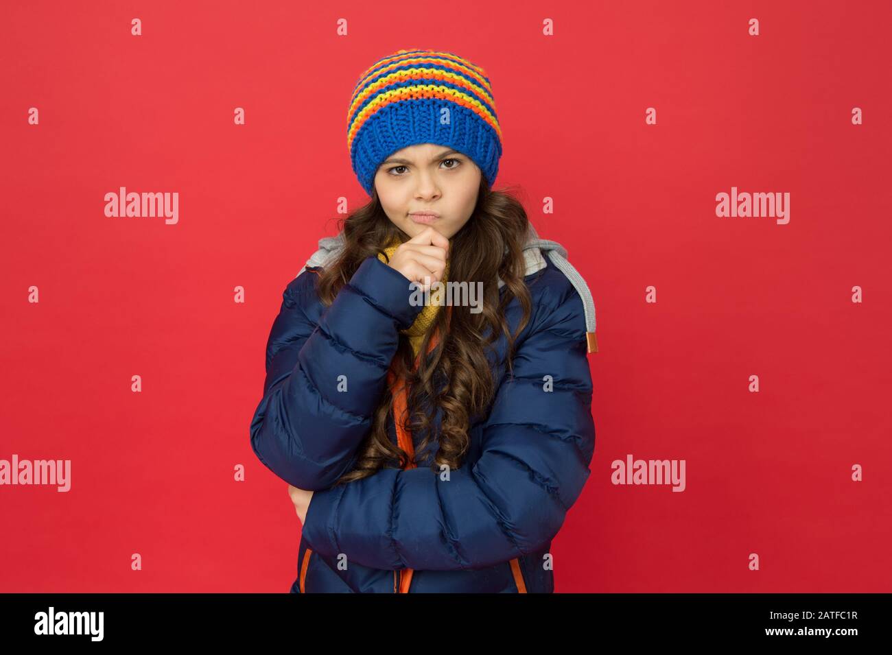 Reluctant to do something. Thoughtful doubtful kid. Little girl wear ...