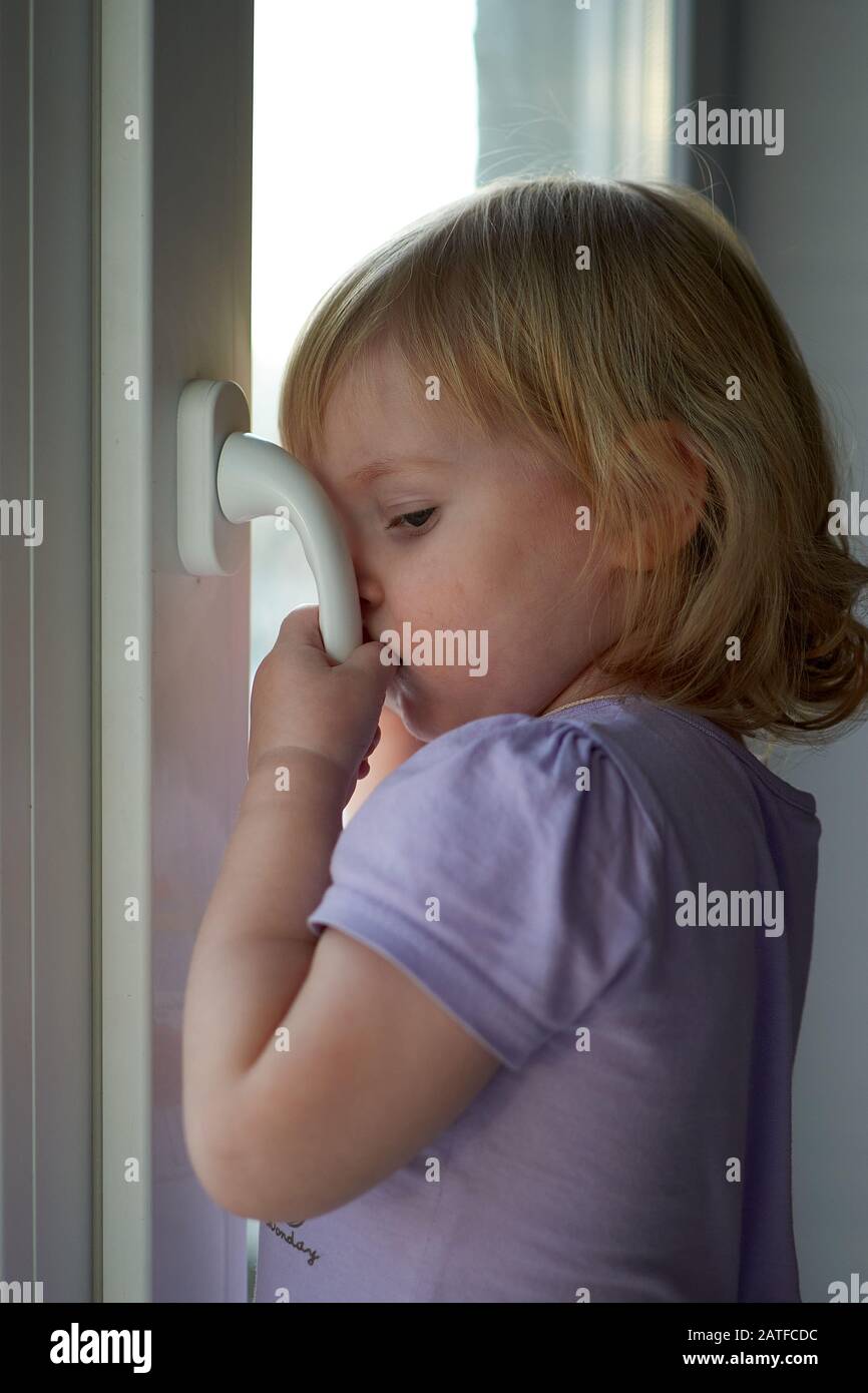A little girl standing in front of a window Stock Photo - Alamy