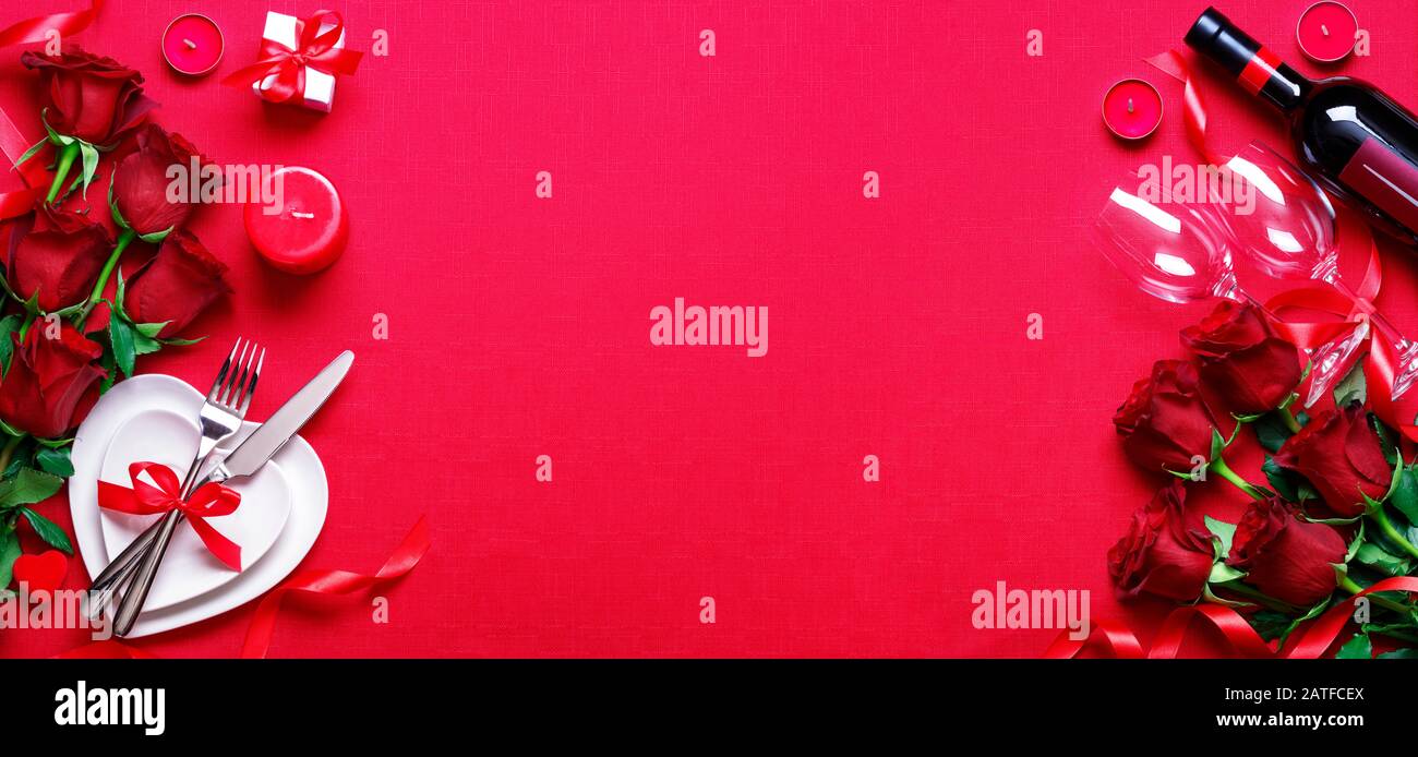 Valentines Day Dinner - Red Romantic Table Setting With Wine Gift And Red Roses Stock Photo - Alamy