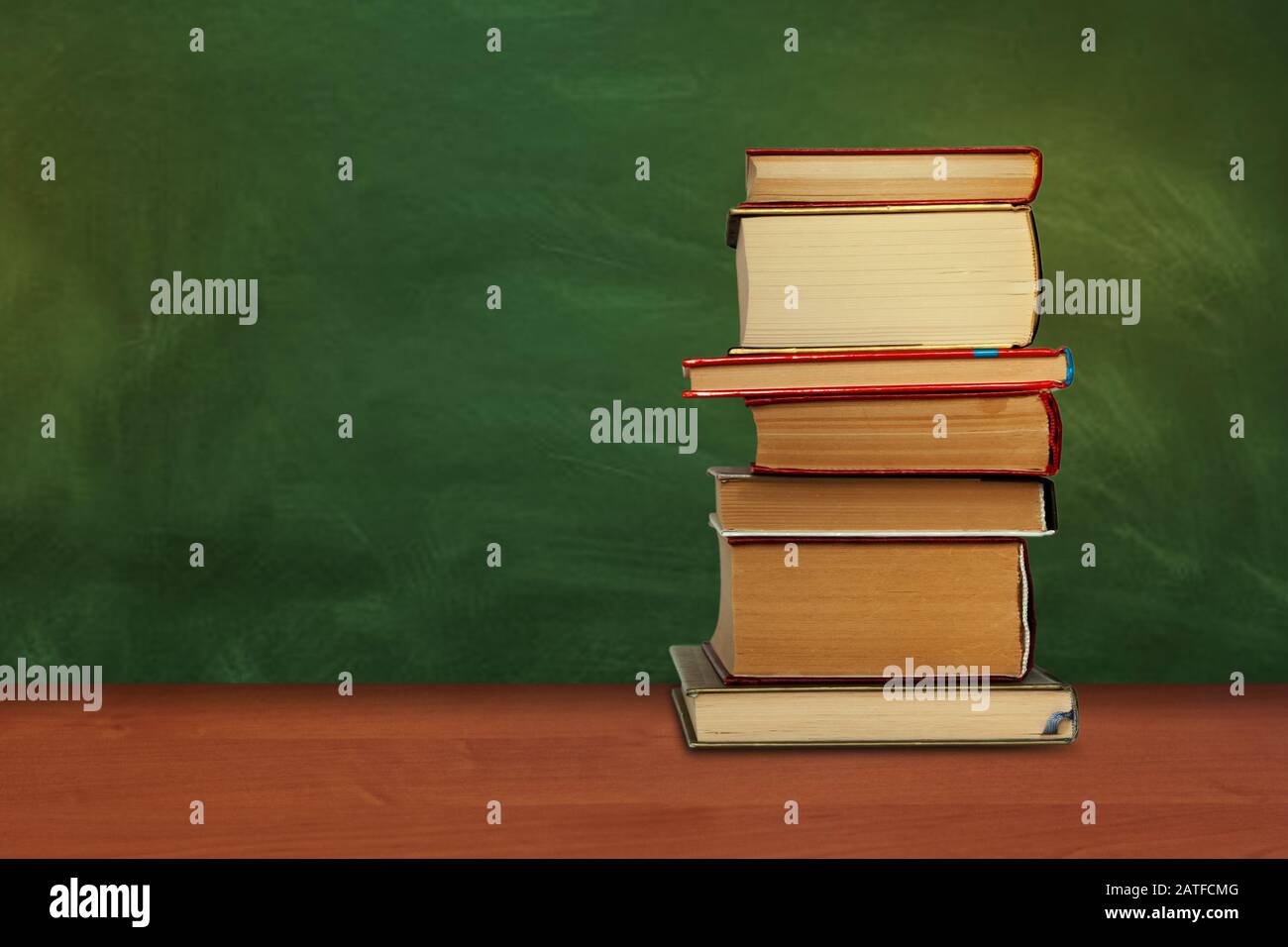 Back to school, pile of books with empty green school board background ...