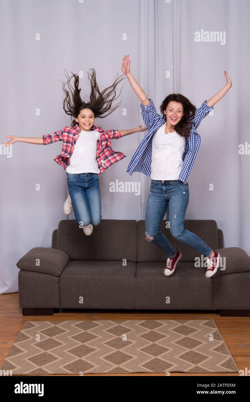 Fun leisure at home. girls party at home. happy sisters jump in freedom ...