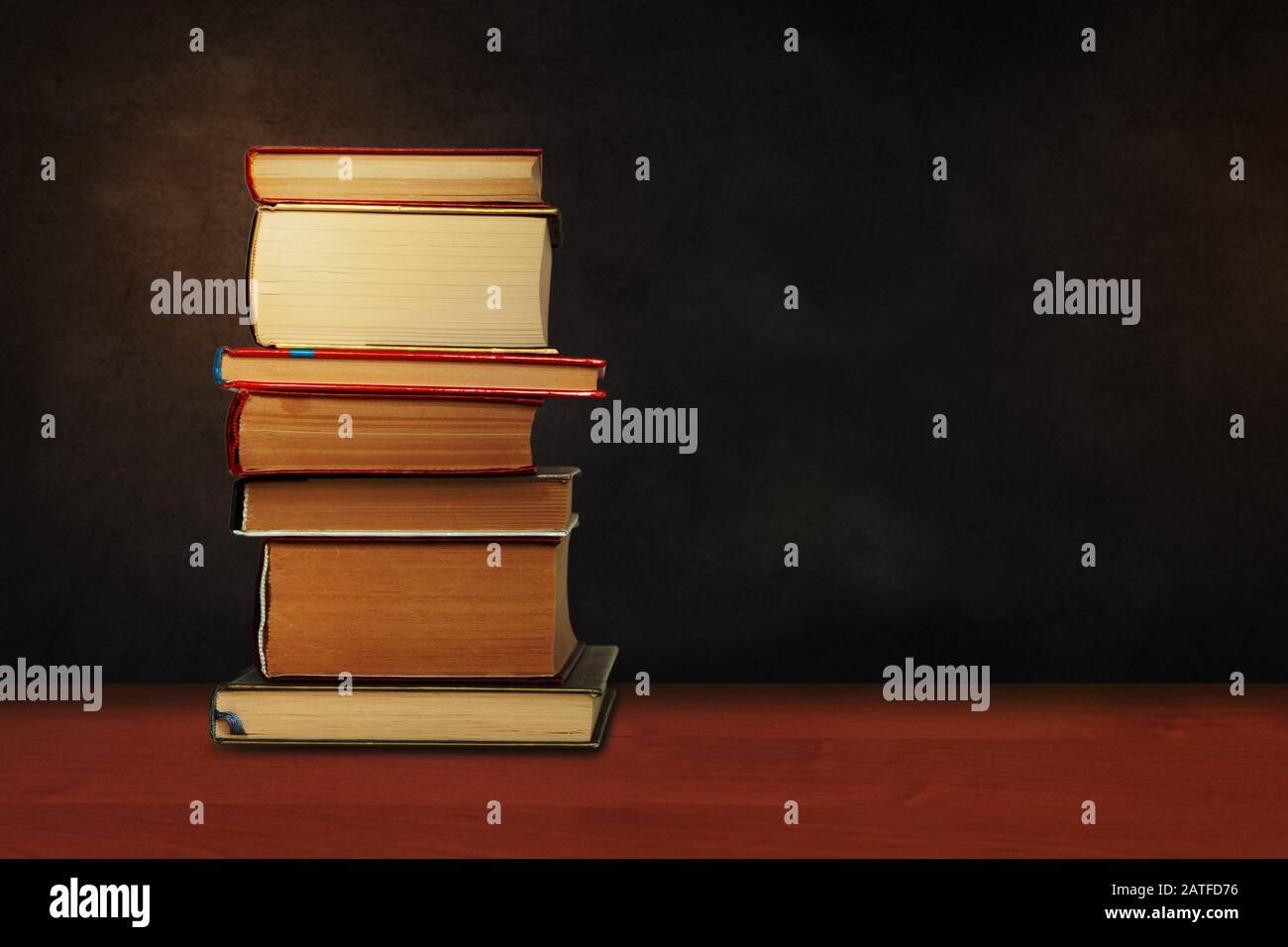 Back to school, pile of books with empty black school board background ...