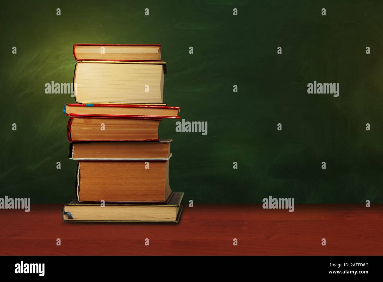 Back to school, pile of books with empty green school board background ...