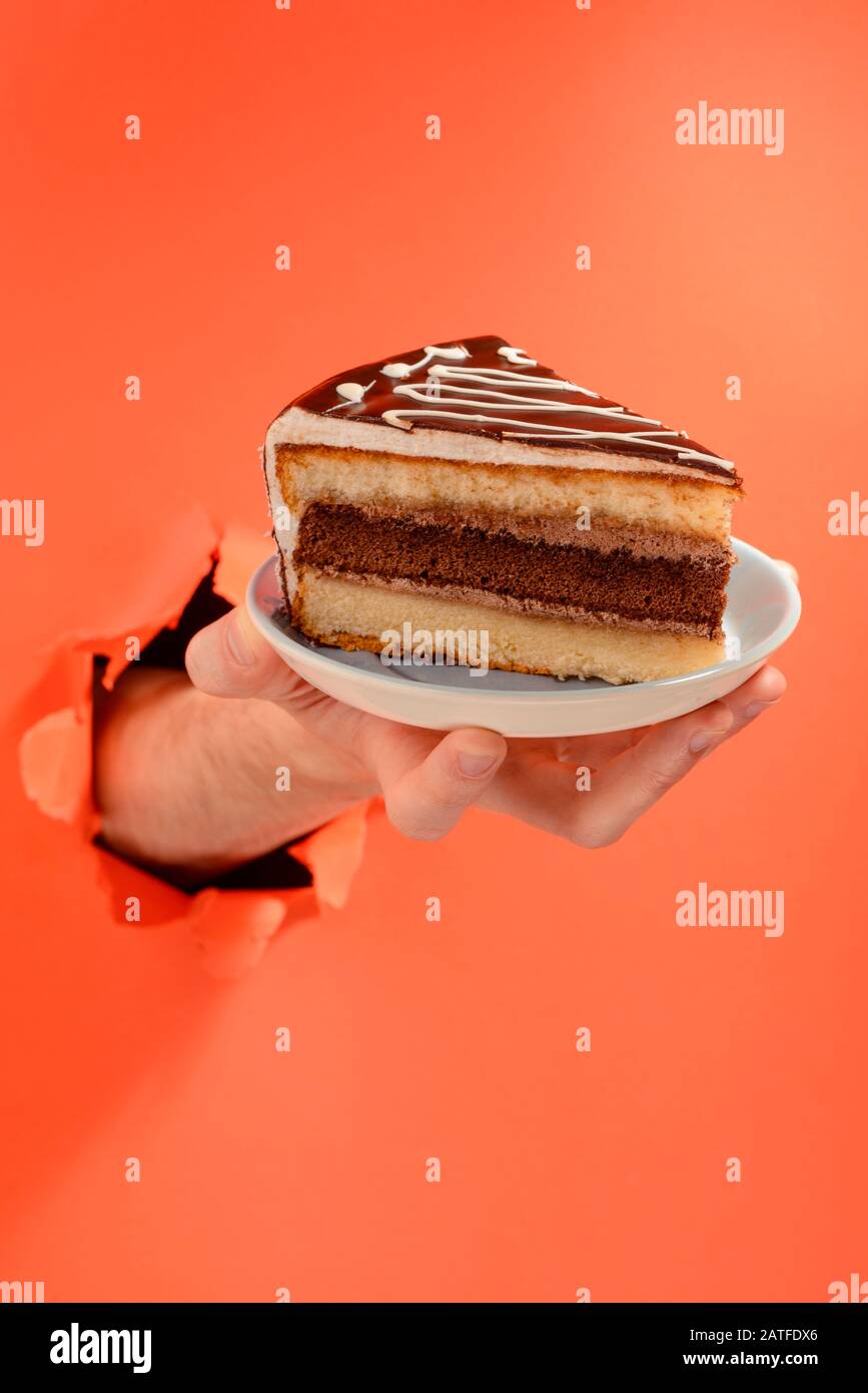 Hand giving a slice of chocolate cake Stock Photo - Alamy