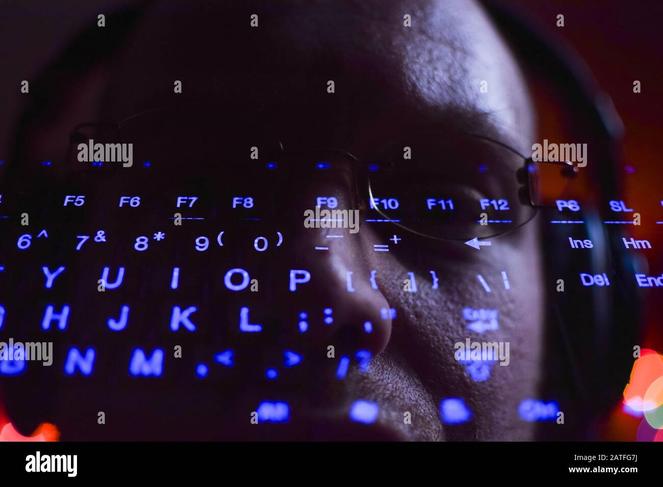 Double exposure of computer keyboard and closeup of male model's face ...