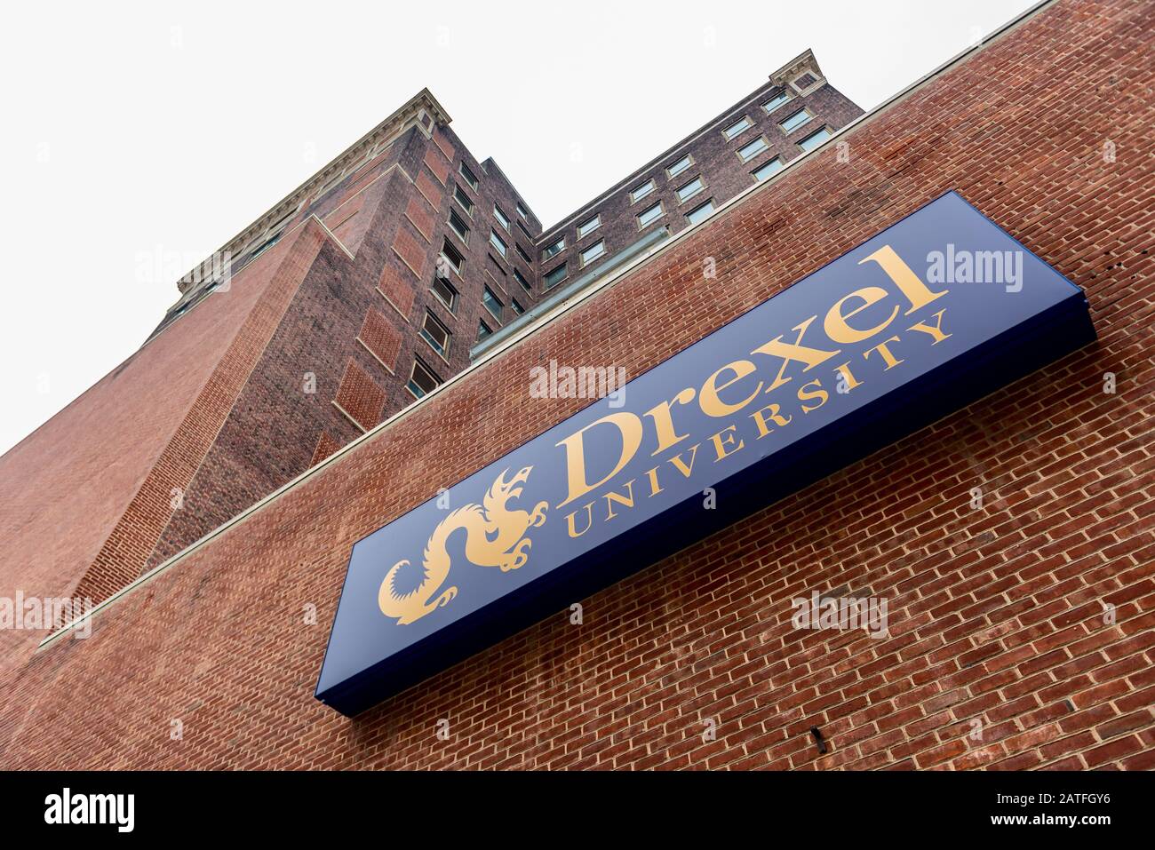 A blue sign with yellow lettering for Drexel University on a red brick ...