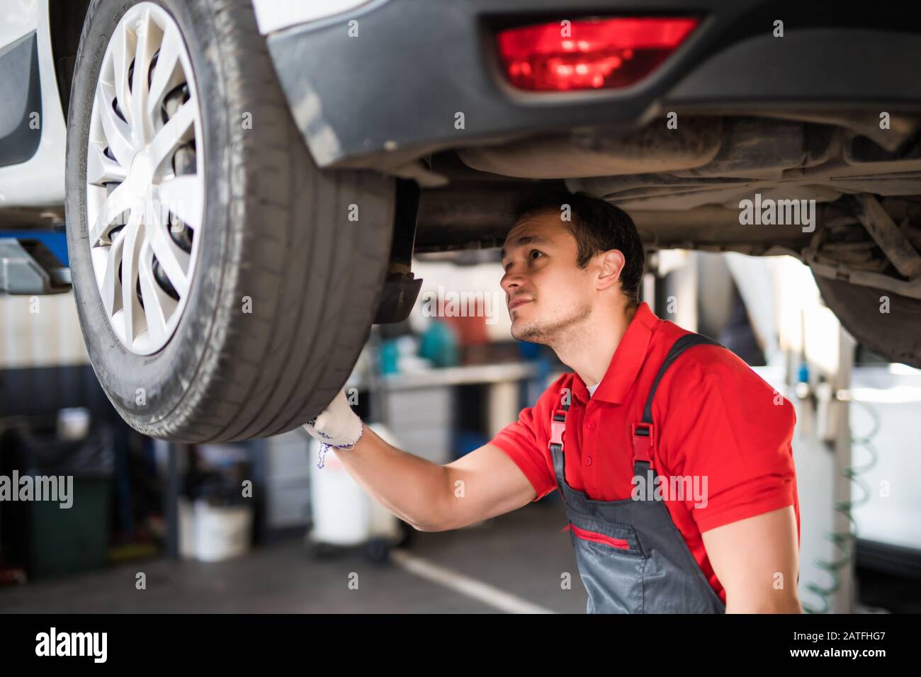mechanic with tool checking the car Stock Photo - Alamy