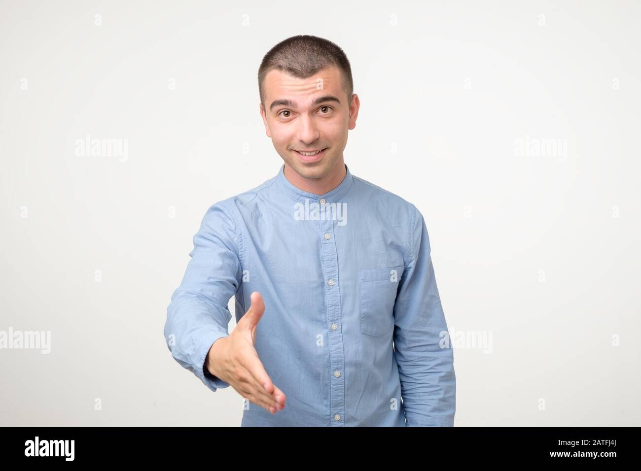 Welcome concept. Handsome young hispanic man stretching out hand for ...