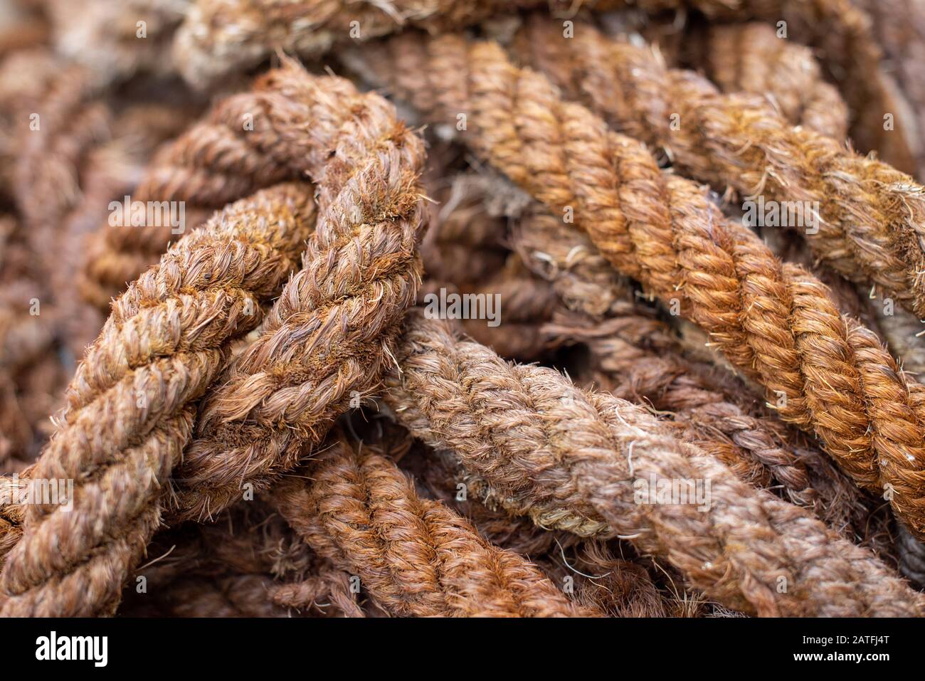 Closer look at the rough texture of a twisted hemp rope tied to an old ...