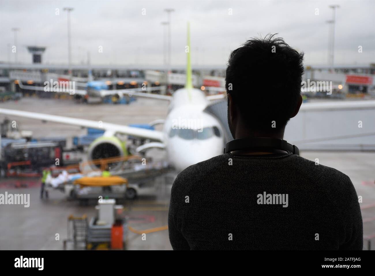 Man at the airport waiting and looking at the departing planes from a ...