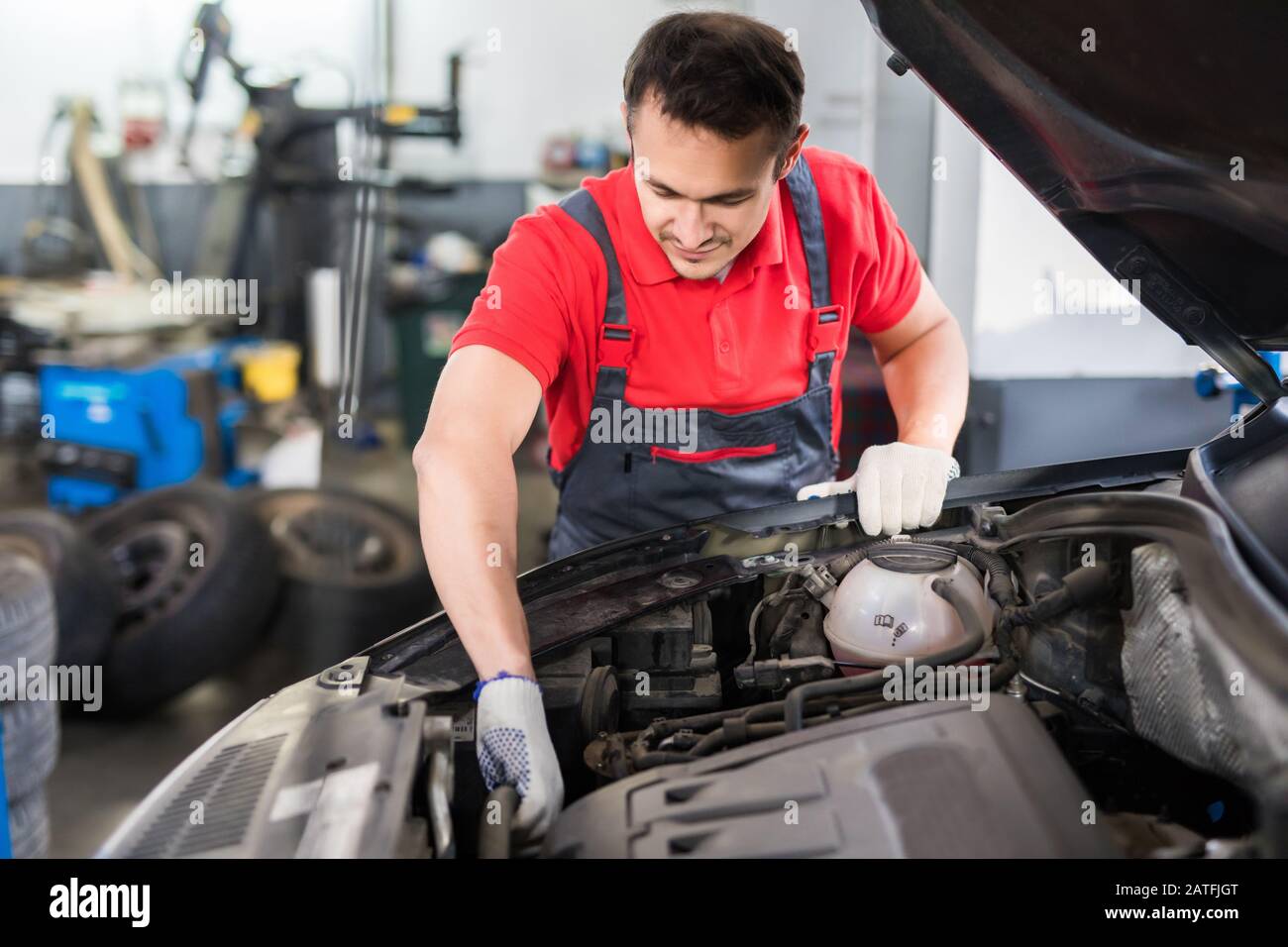 Auto mechanic checking car engine at the garage Stock Photo - Alamy