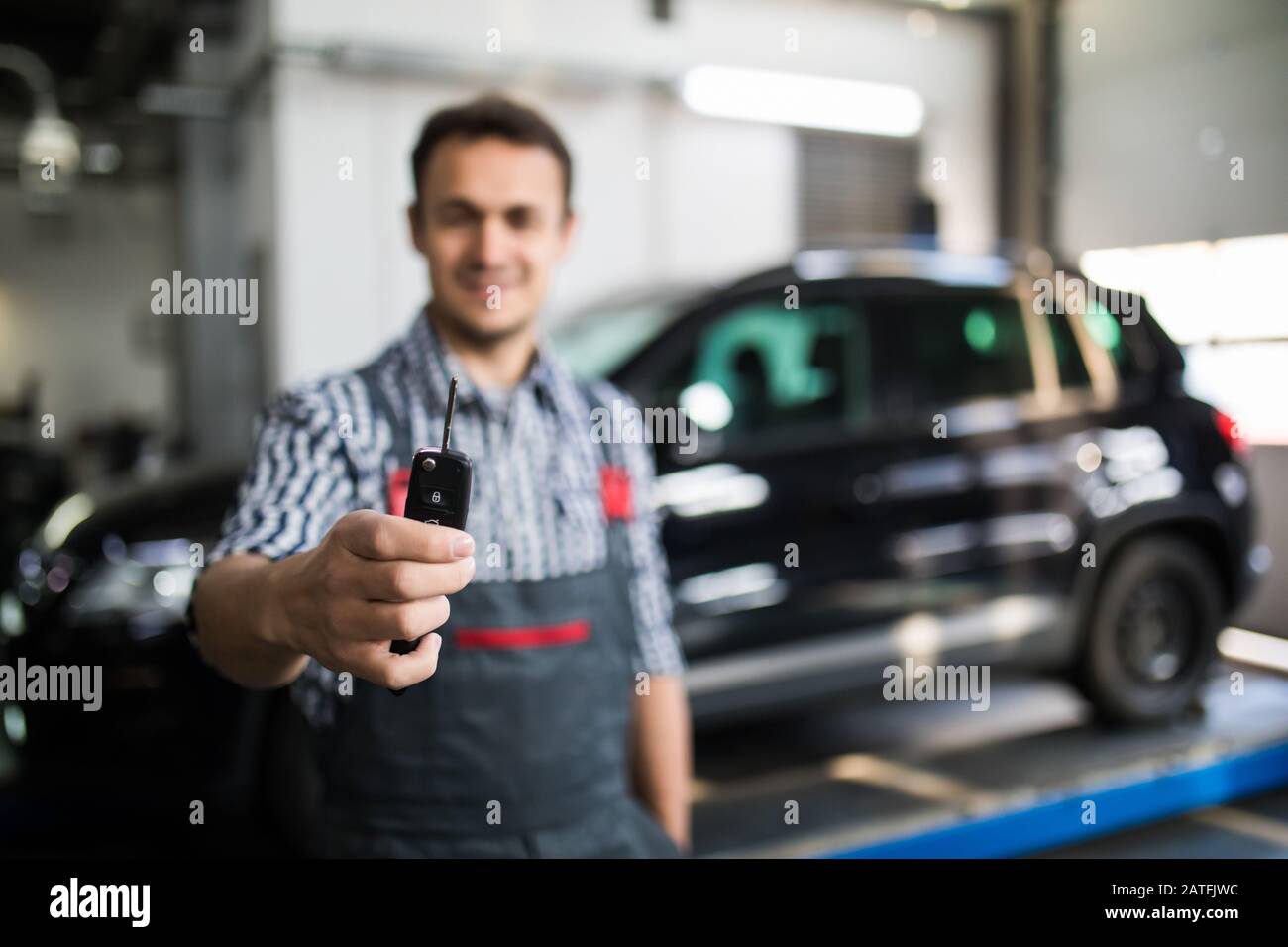 Mechanic handling keys of a car at the garage Stock Photo - Alamy