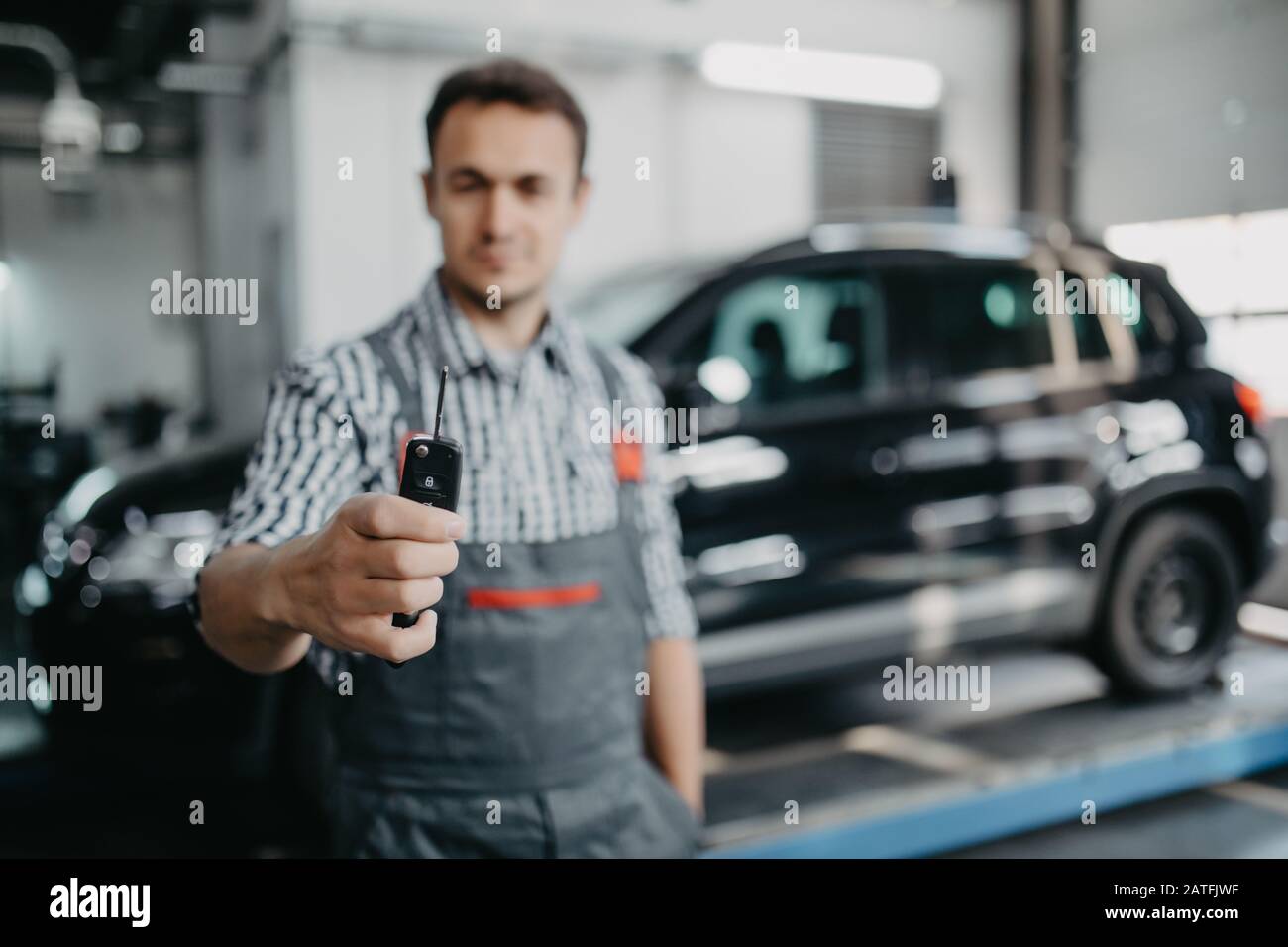 Mechanic handling keys of a car at the garage Stock Photo - Alamy