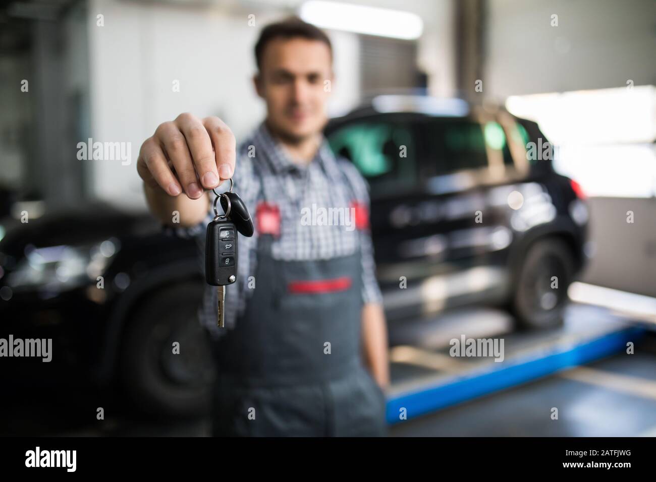 Mechanic handling keys of a car at the garage Stock Photo - Alamy