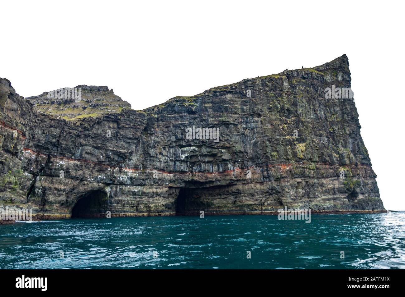 Steep coastline with vertical cliff and caves Stock Photo - Alamy