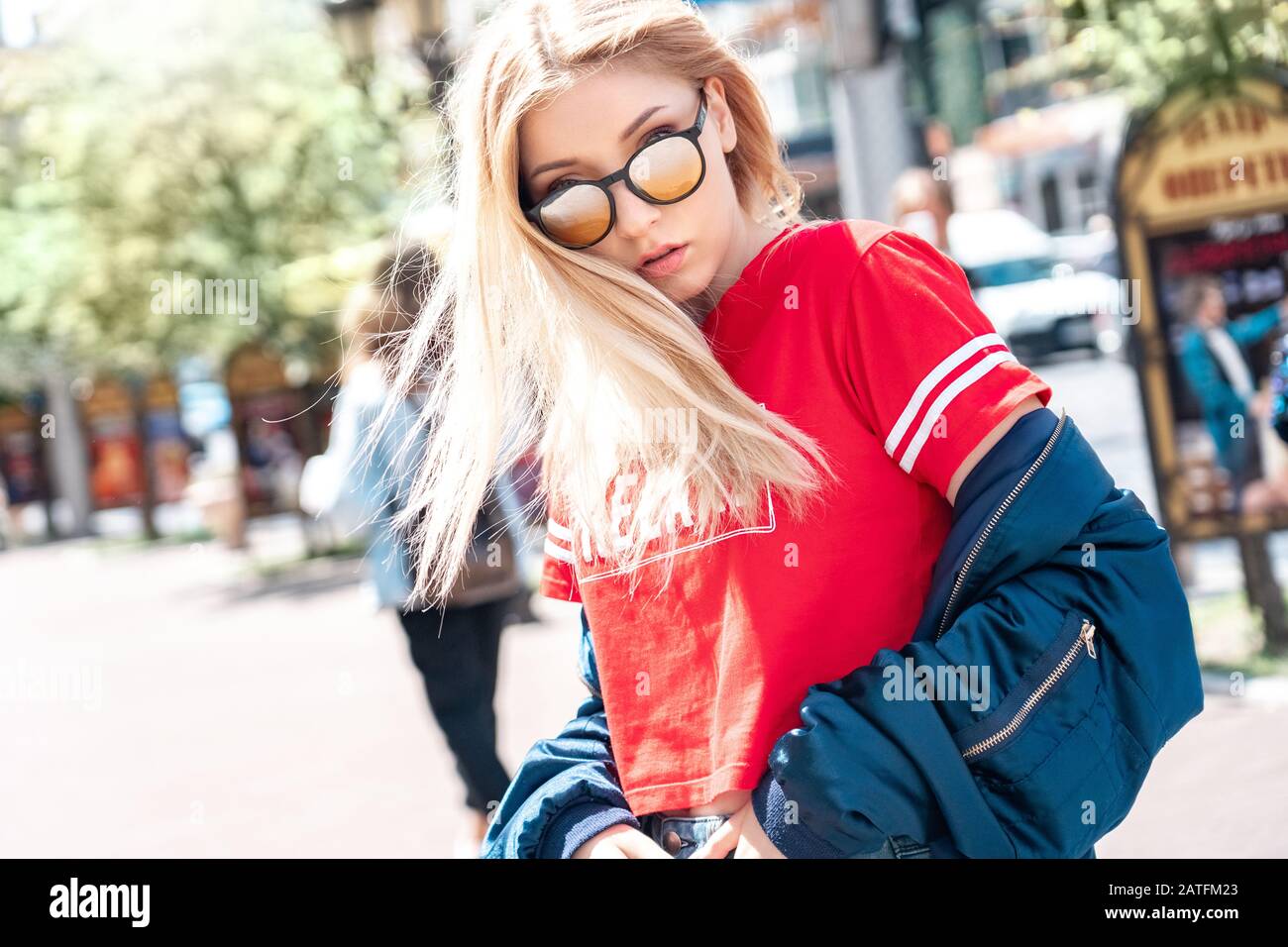 Outdoors Recreation. Teen girl student in denim jacket and sunglasses walking on urban ...
