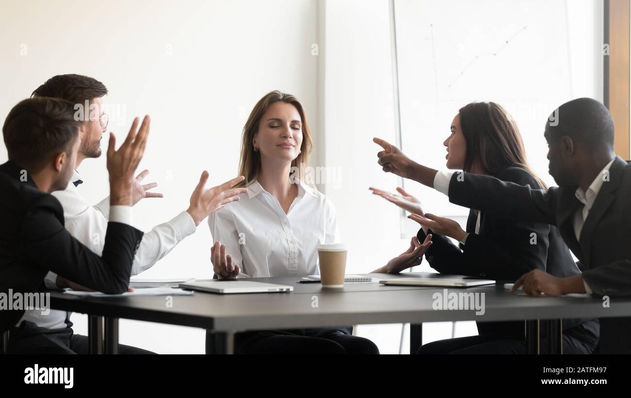 While stressed colleagues screaming to young businesswoman she ...