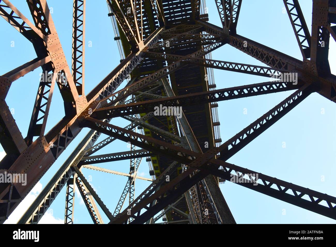 Metal rusty brown rail road bridge debris from below. Railway across ...