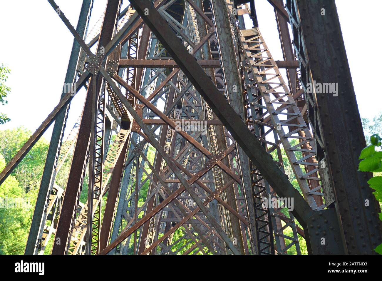 Metal rusty brown rail road bridge debris from below. Railway across ...