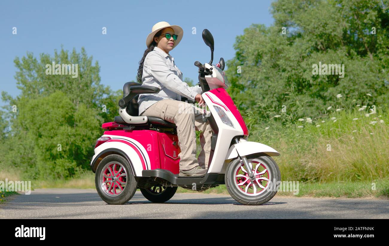 Woman with special needs riding electric wheel chair to aid with ...