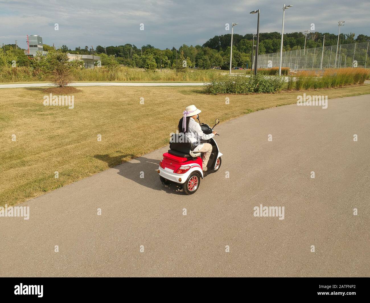 Disabled person driving a motorized mobility scooter for elderly and or ...