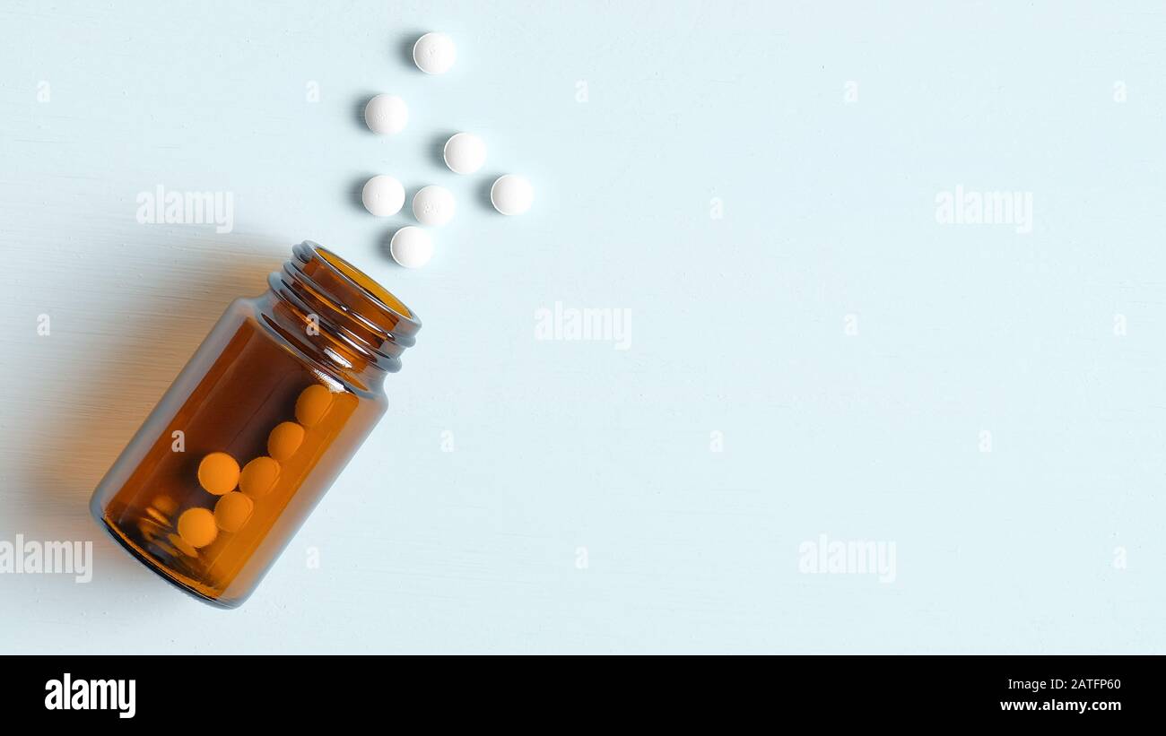 Pills spilling from a bottle top view. Pharmacy store or medical clinic ...