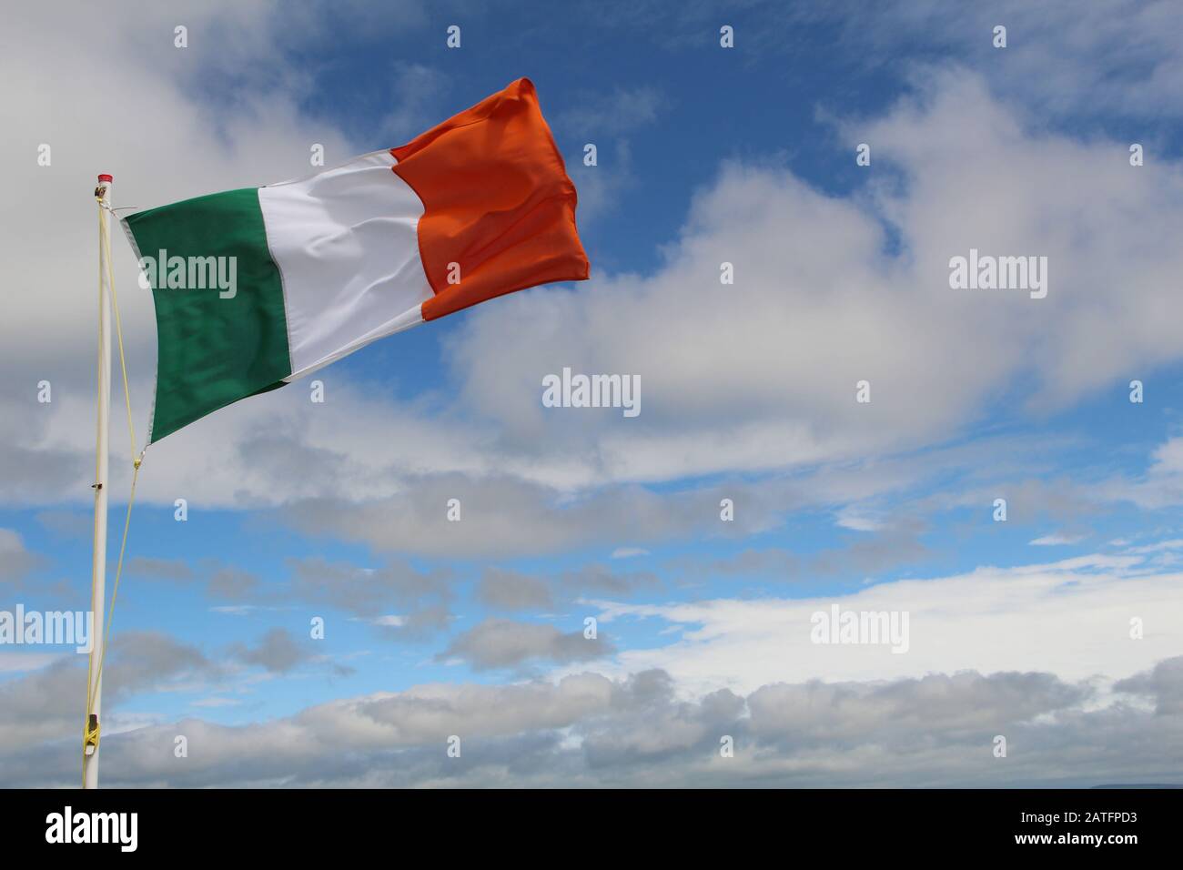 Irish Flag isolated with blue sky and cloud background Stock Photo - Alamy