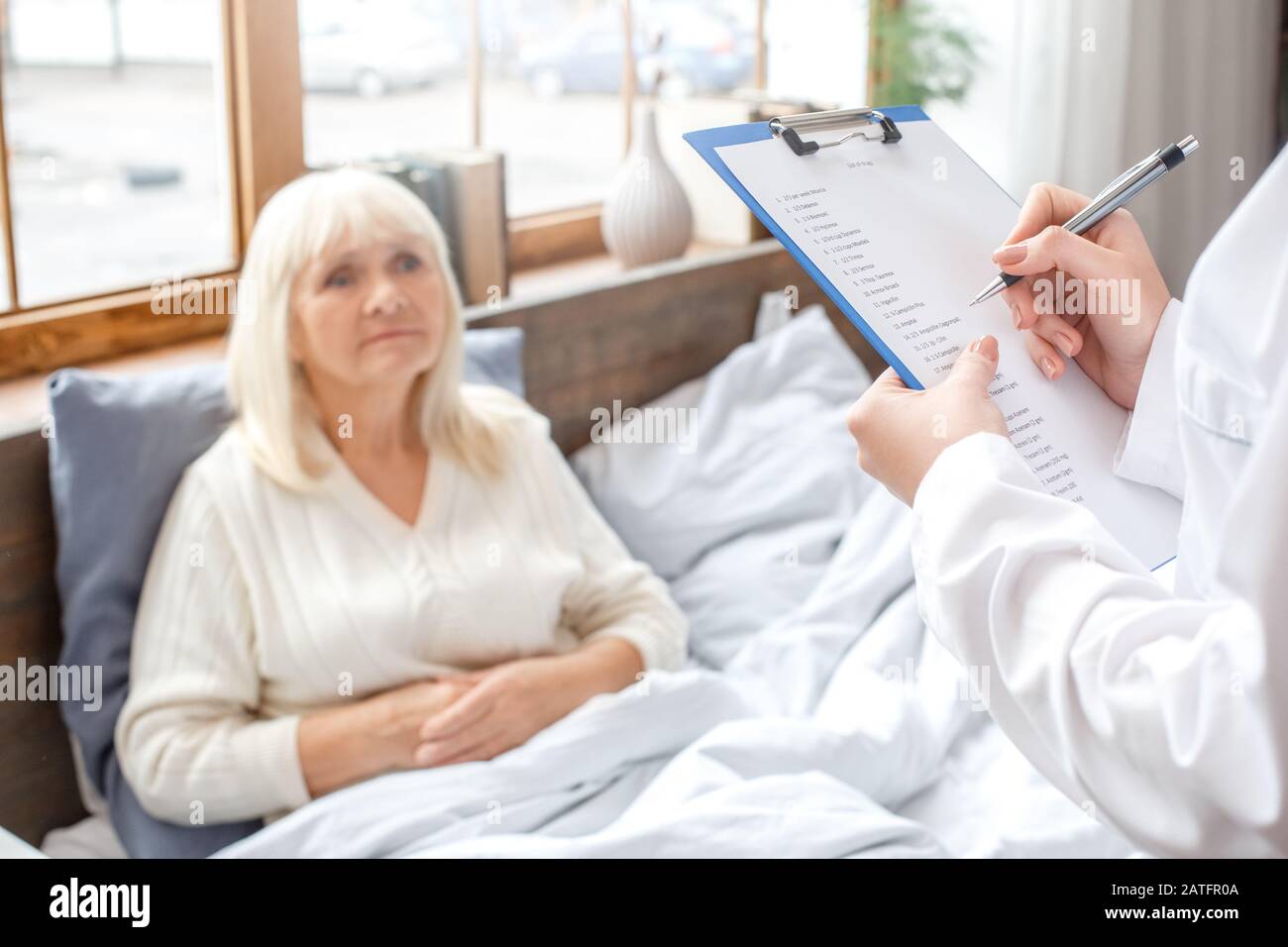 Nurse taking care of senior woman writing prescription retirement ...