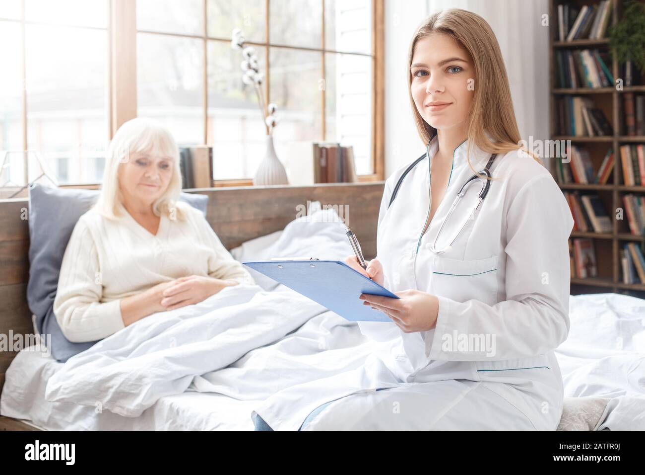 Nurse taking care of senior woman writing prescription retirement ...