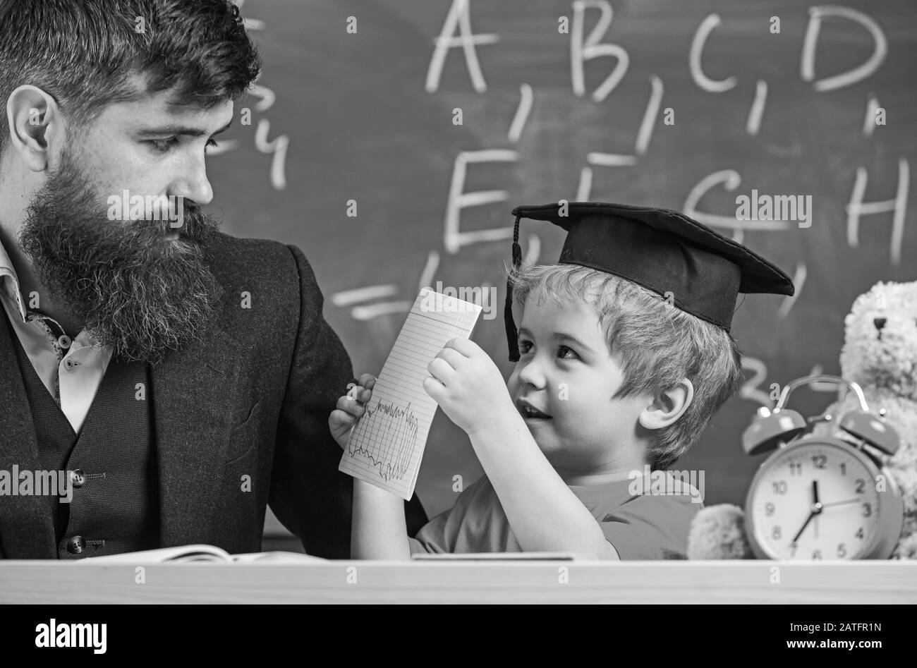 Teacher, father checking homework, helps to boy, son. Individual ...