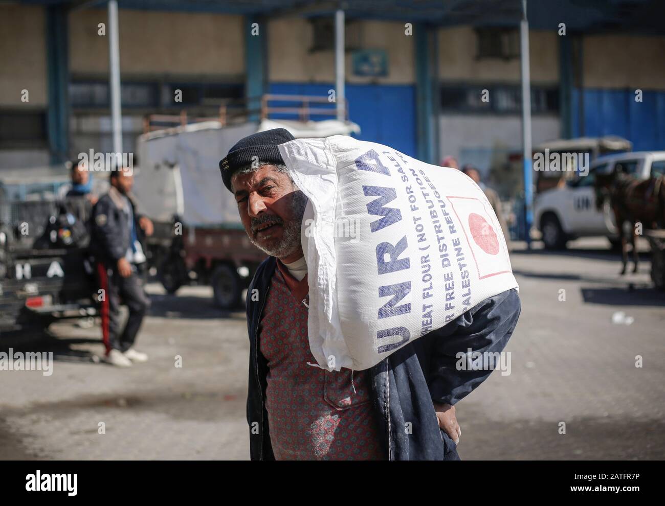 A man carries a sack of flour part of the food aid from United Nations ...