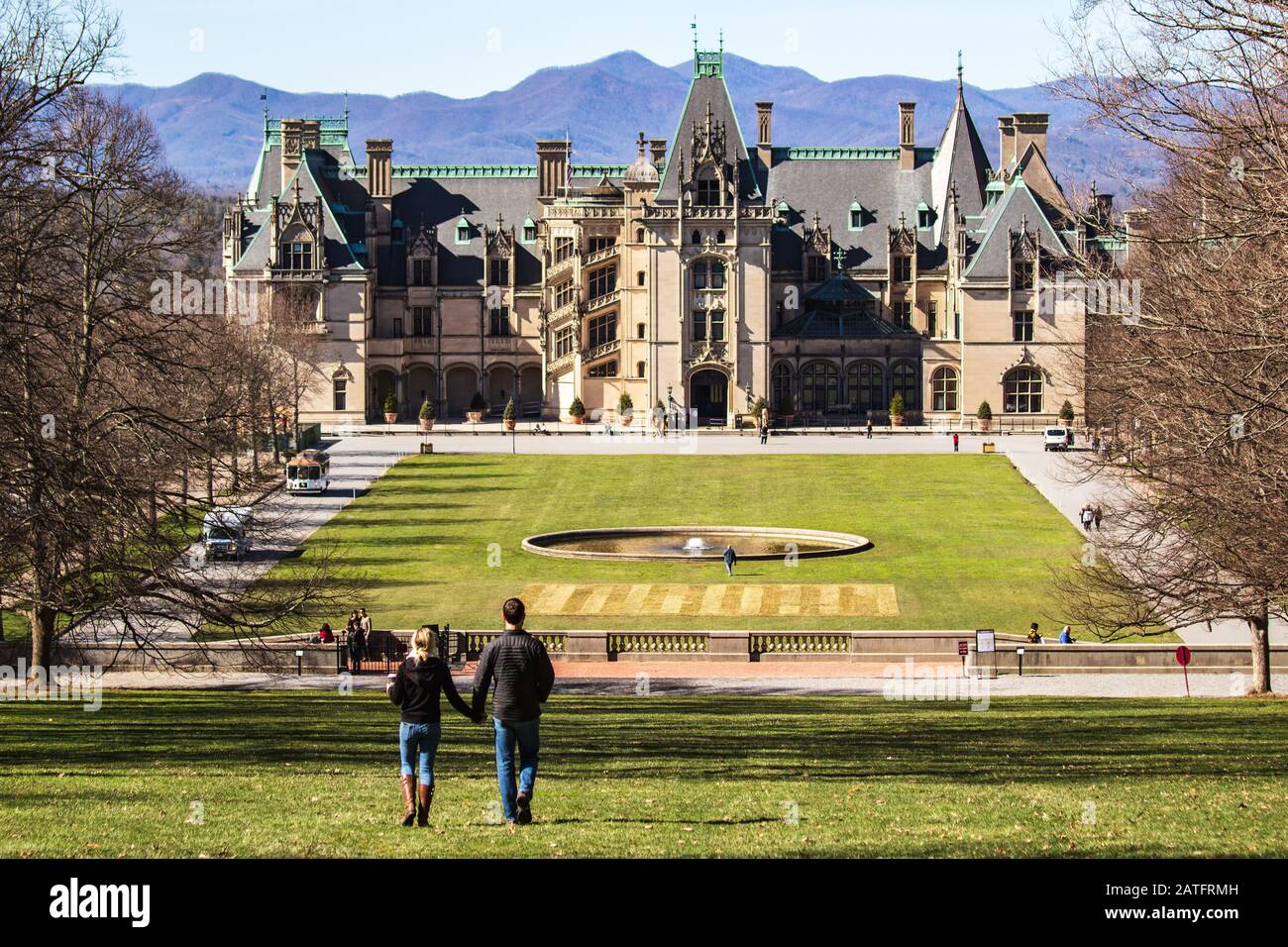 Tourists stroll towards the Biltmore House, with the Blue Ridge ...