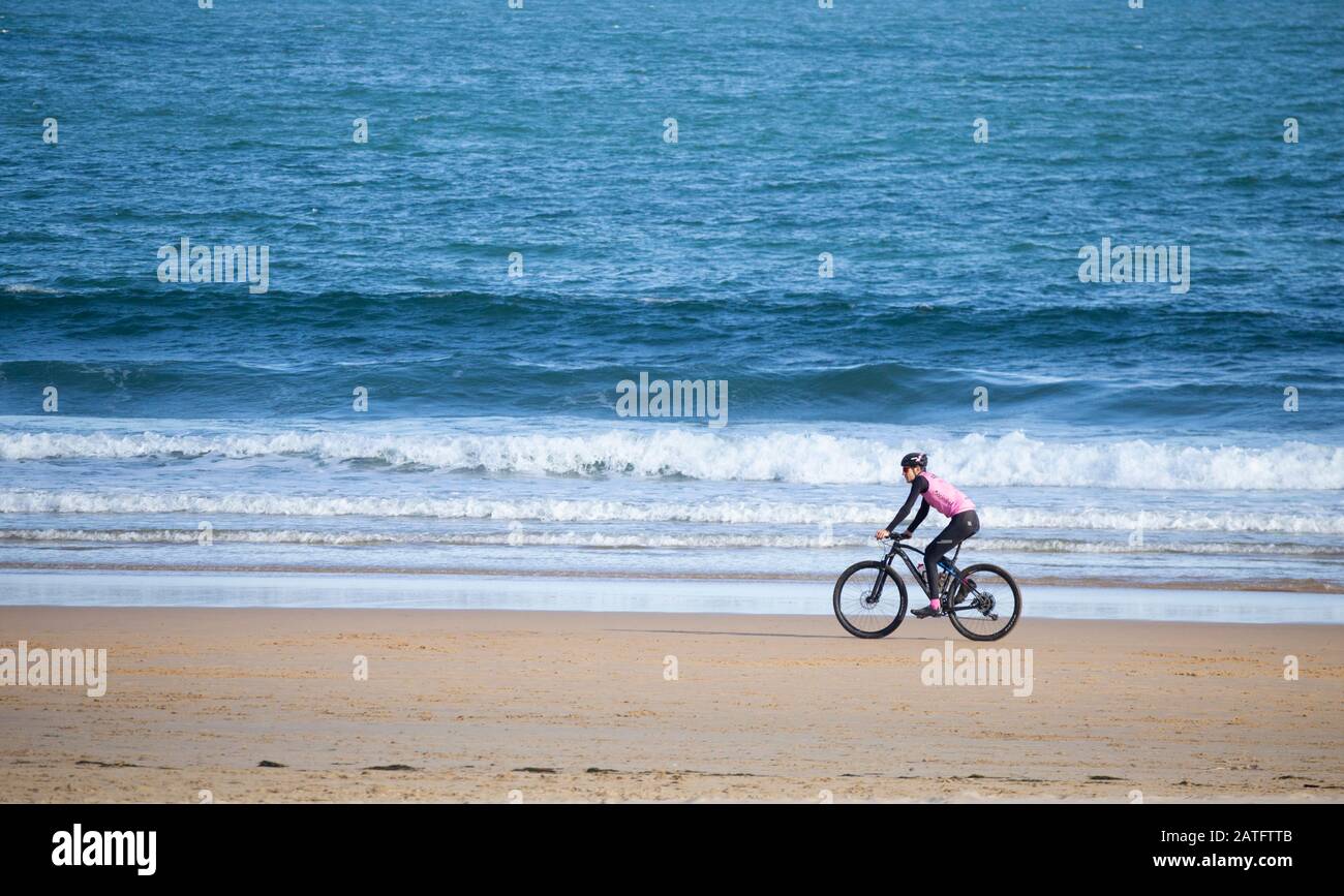 Mountain biker riding on beach Stock Photo - Alamy