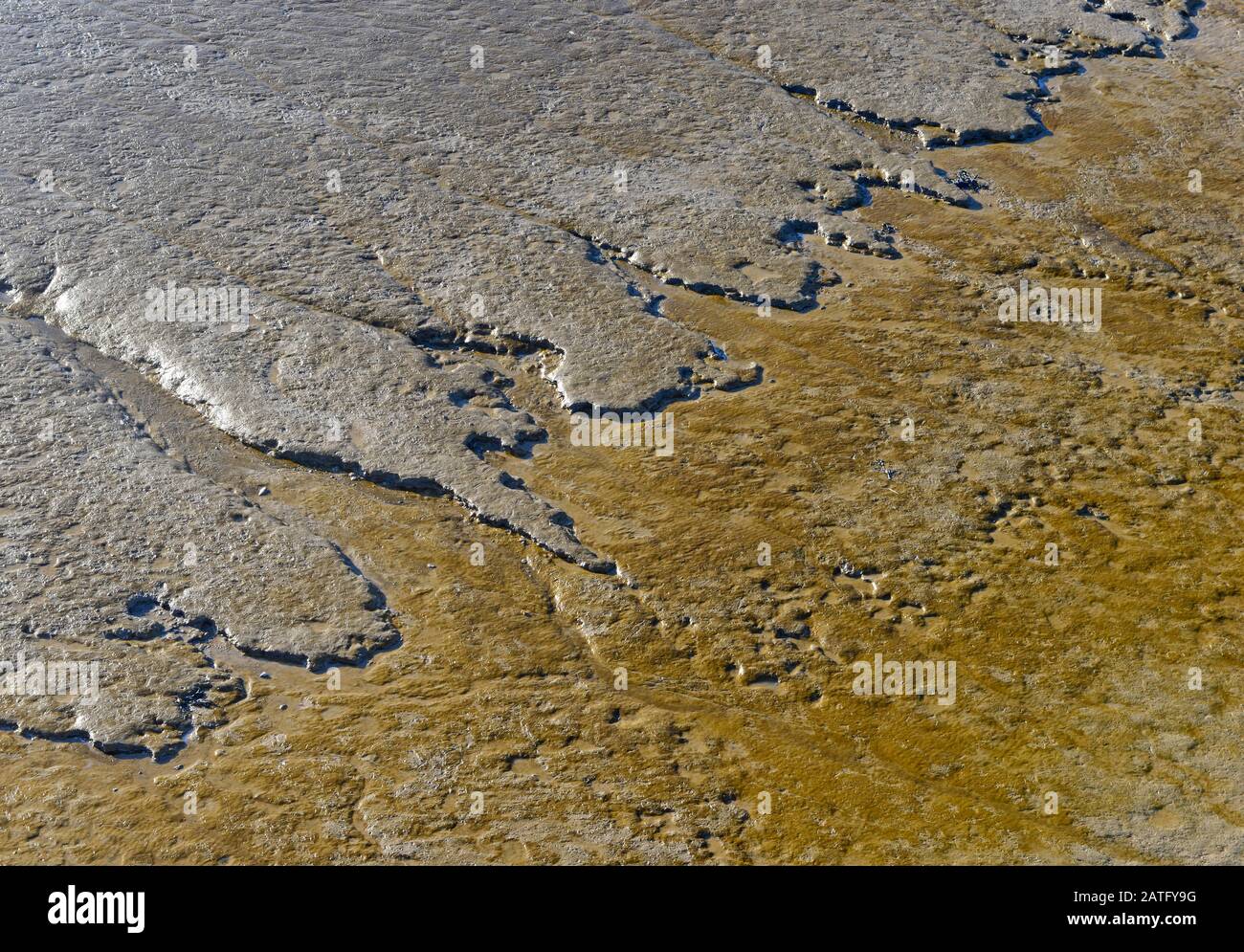 The mud, exposed at low tide, in Watchet harbour, Somerset, UK, looks ...