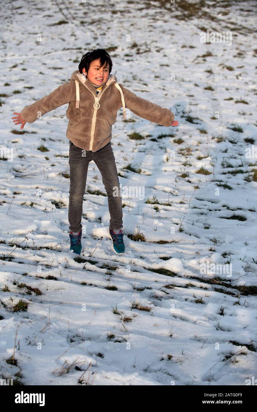 Child jumping on snow Stock Photo - Alamy