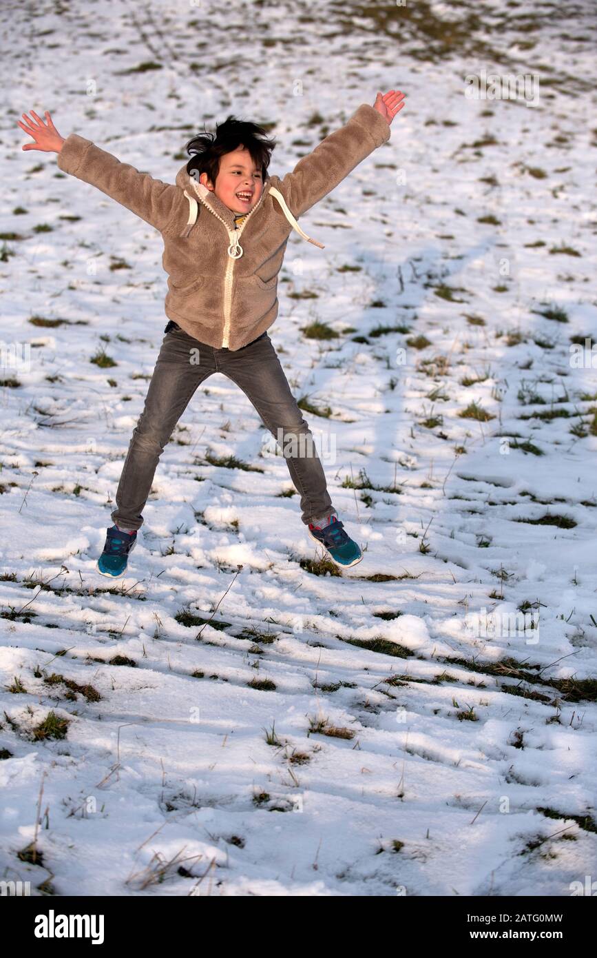 Child jumping on snow Stock Photo - Alamy