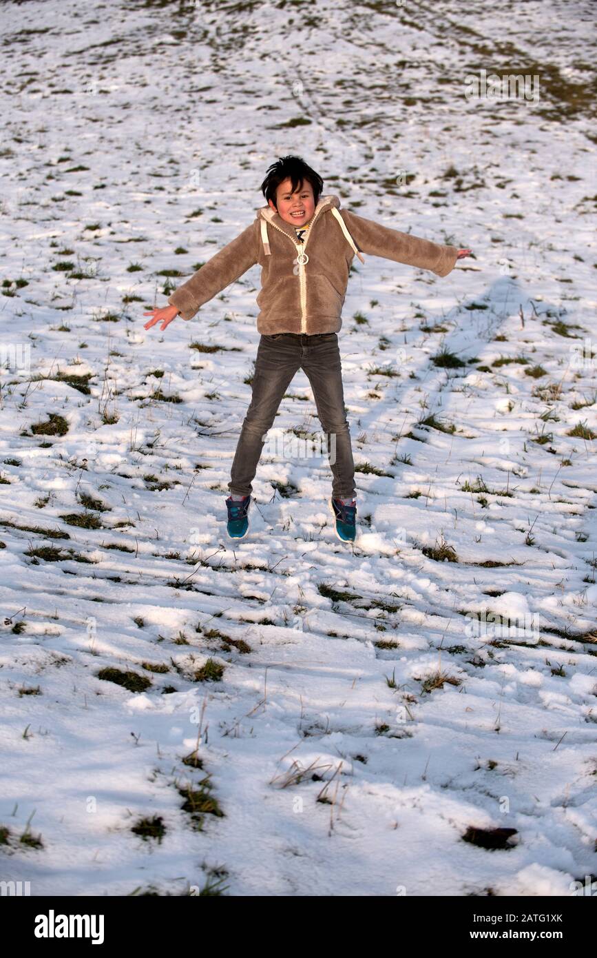 Child jumping on snow Stock Photo - Alamy