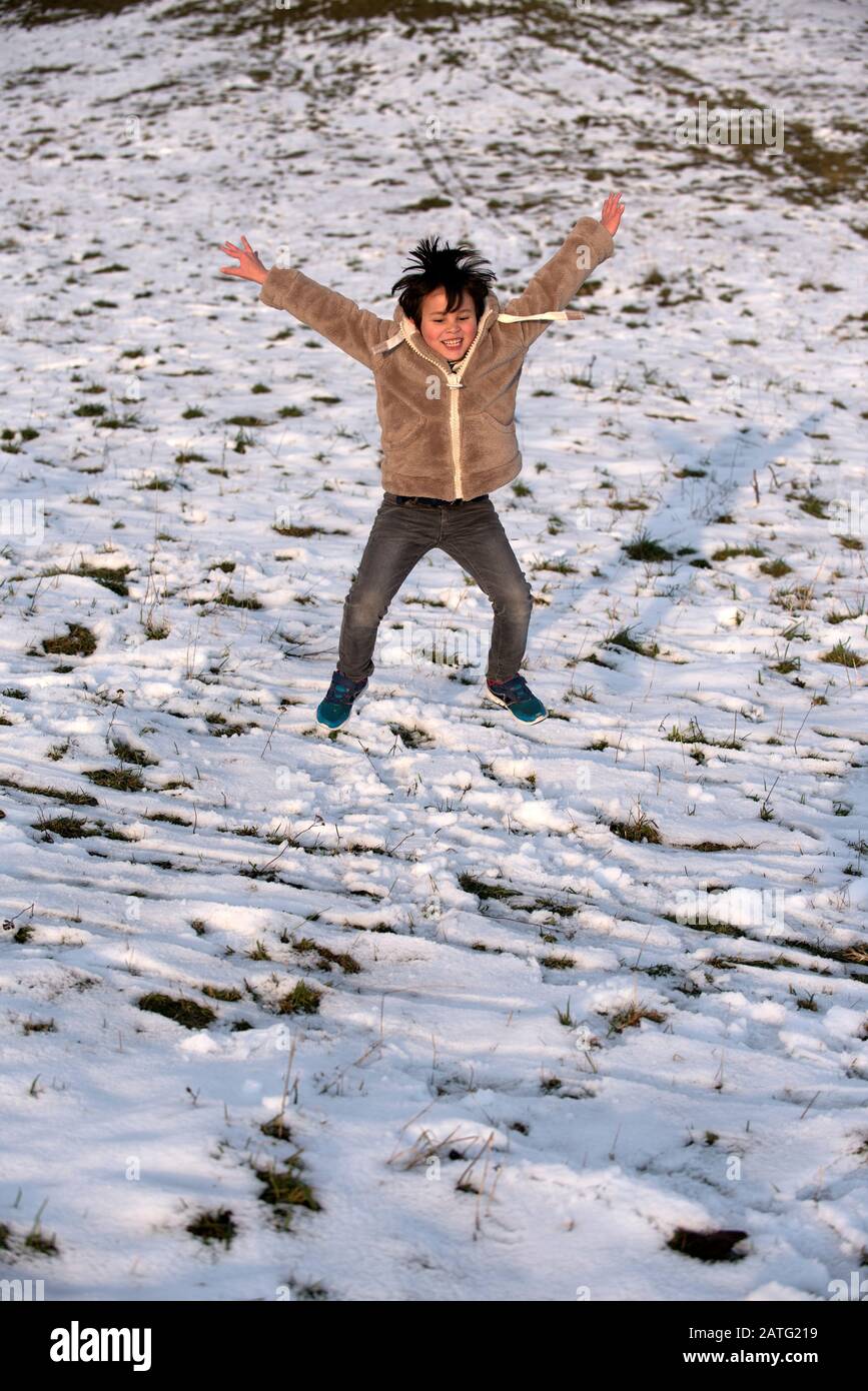 Child jumping on snow Stock Photo - Alamy