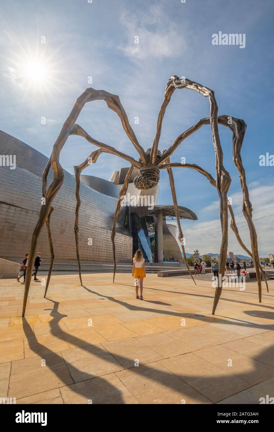 Woman stands under a sculpture of a giant spider at Guggenheim Museum ...